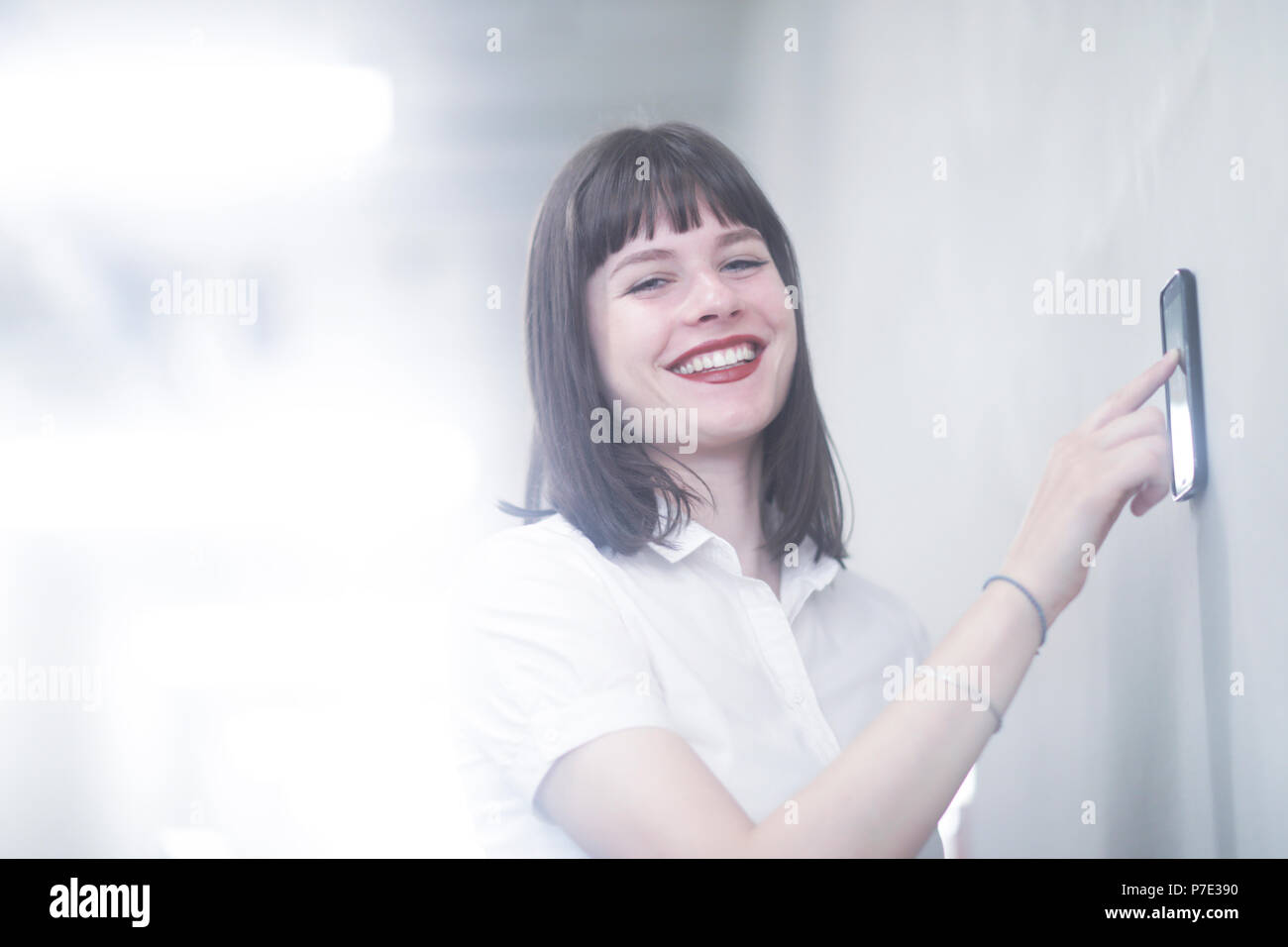 Woman using wall mounted touch screen control panel Stock Photo - Alamy