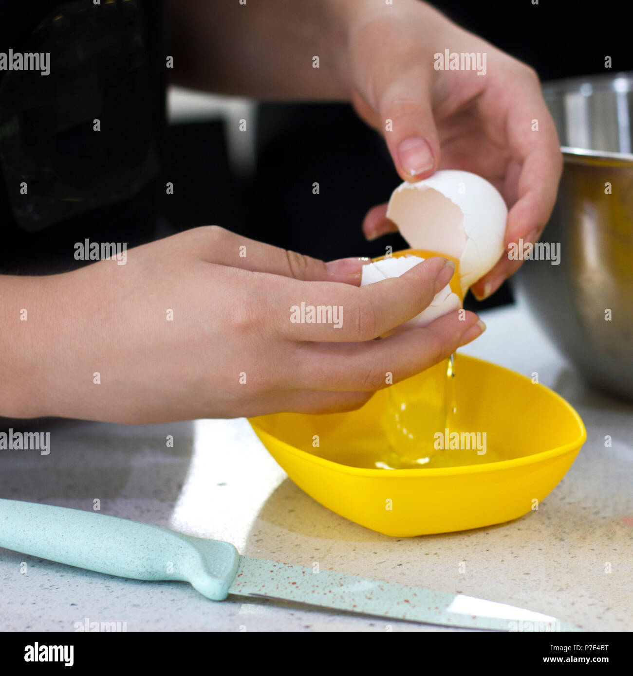 Hands break the raw egg. Separation of egg white from yolk Stock Photo - Alamy