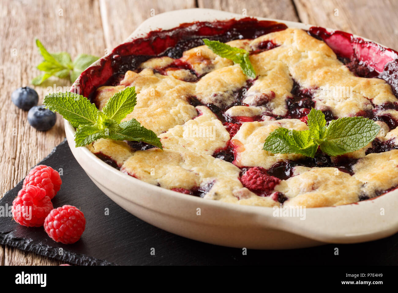 Summer berry cobbler of raspberries and blueberries close up in a dish ...