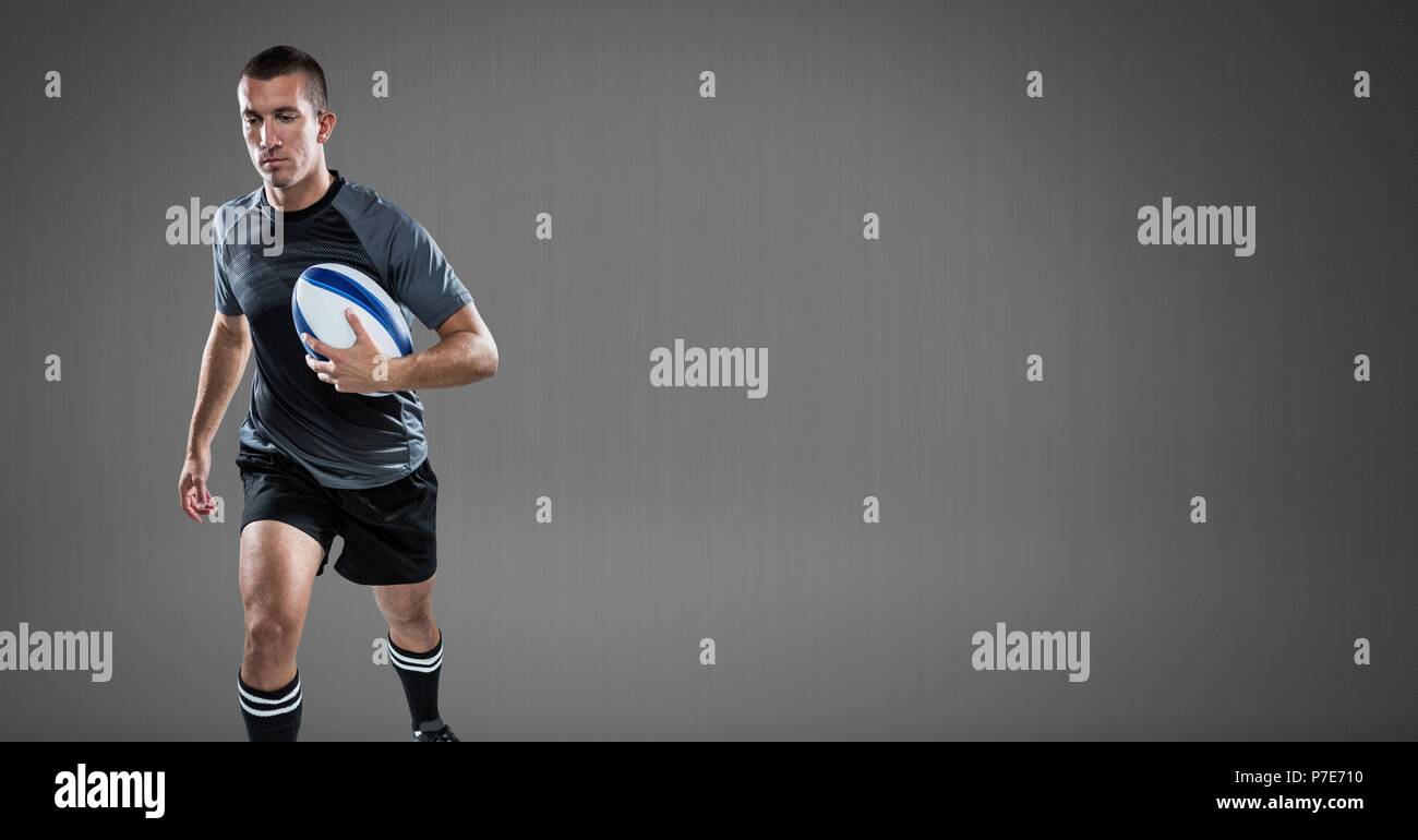 Rugby player holding ball with blank grey background Stock Photo - Alamy