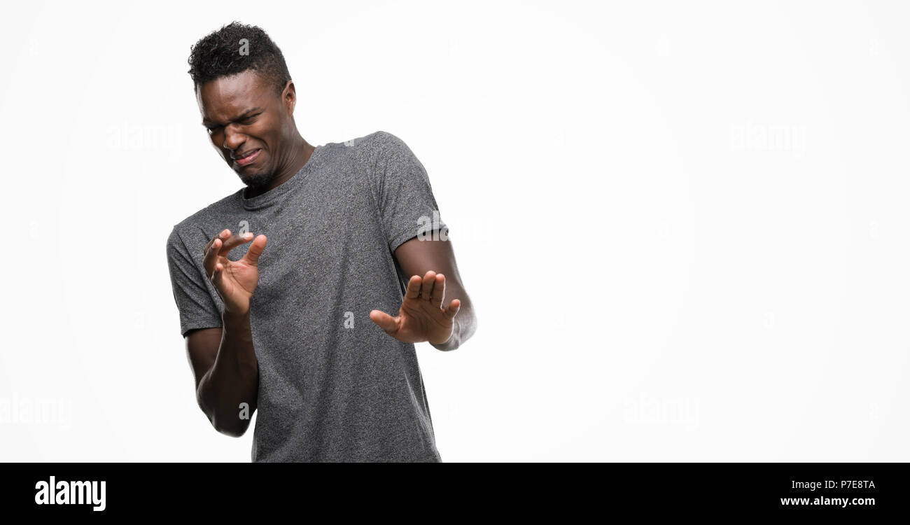 Young african american man wearing grey t-shirt disgusted expression ...