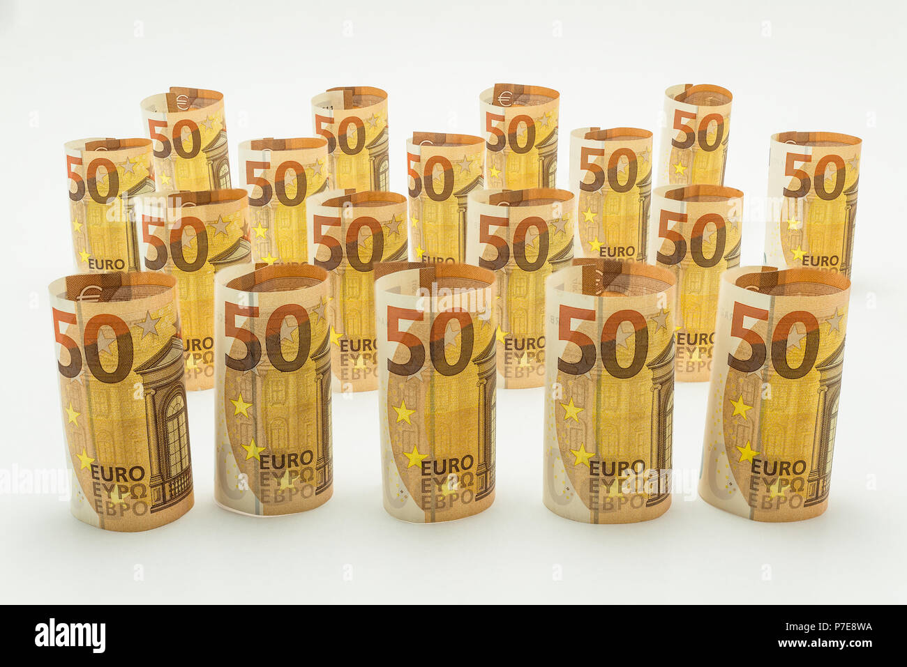 Rolled up 50 euro banknotes in rows. Isolated on a white background ...