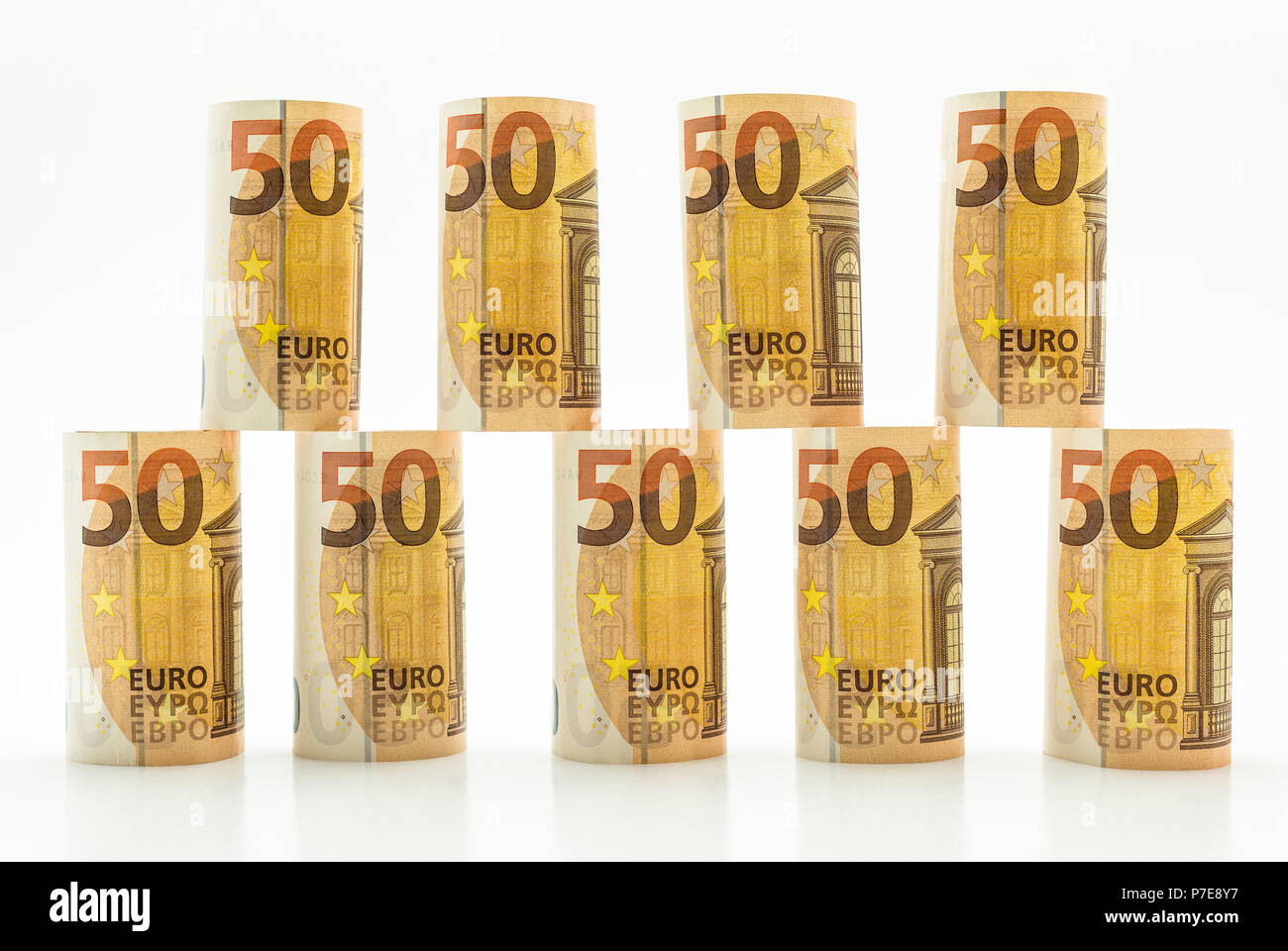 Rolled up 50 euro banknotes in rows. Isolated on a white background ...