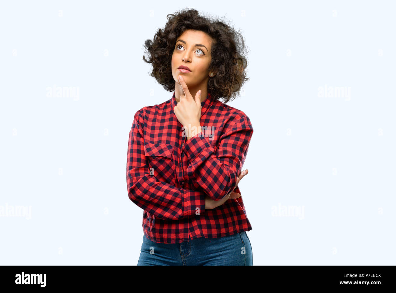 Beautiful arab woman thinking and looking up expressing doubt and ...
