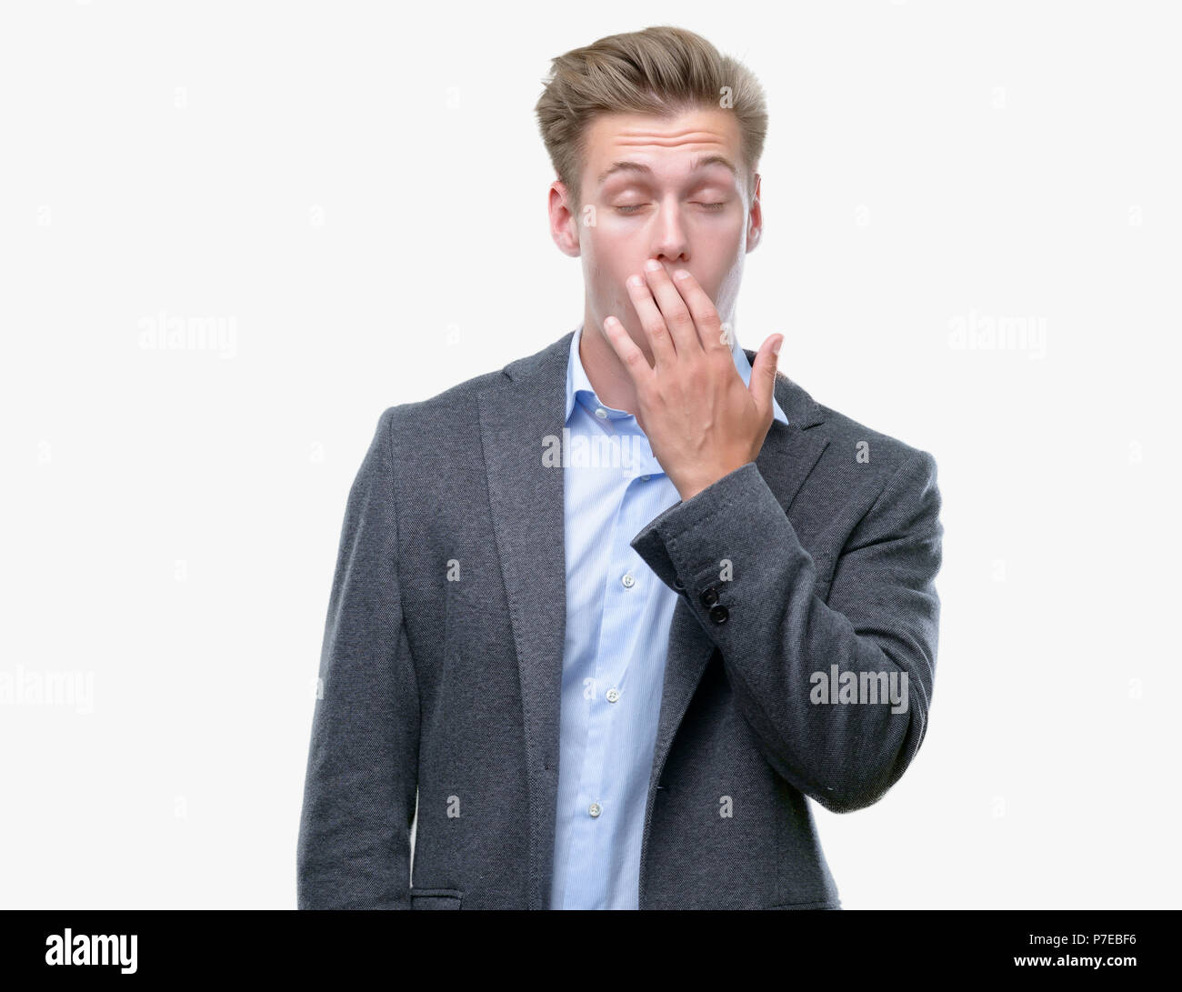 Young handsome blond business man bored yawning tired covering mouth ...