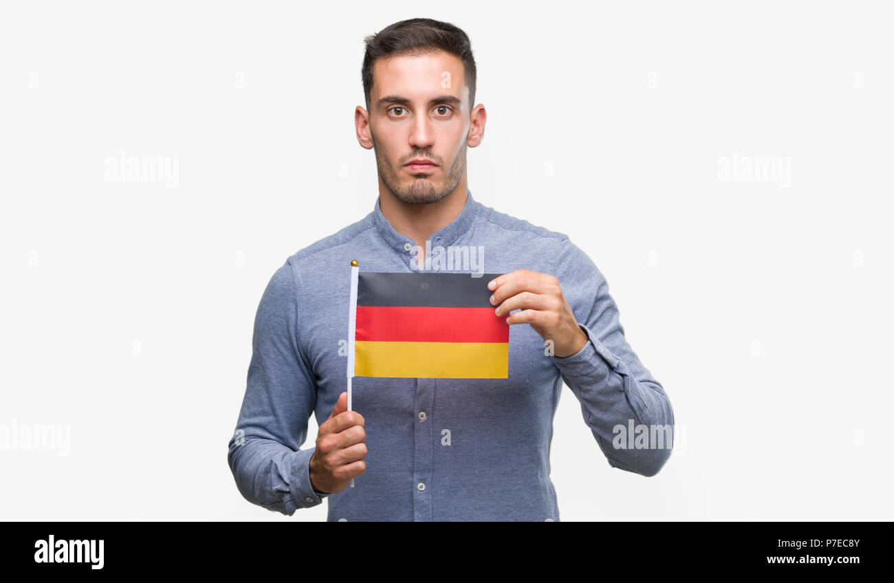 Handsome young man holding a flag of Germany with a confident ...