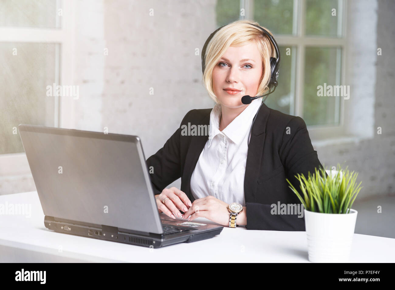 Beautiful blonde adult woman call center operator dressed in black ...