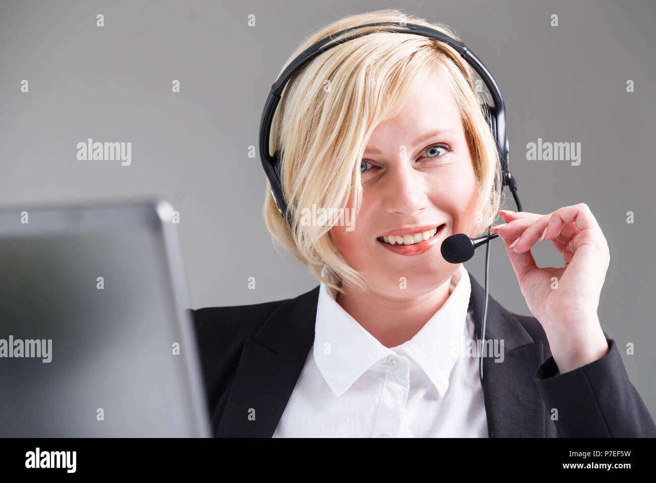 Smiling woman, call center operator dressed in black stylish suit with ...