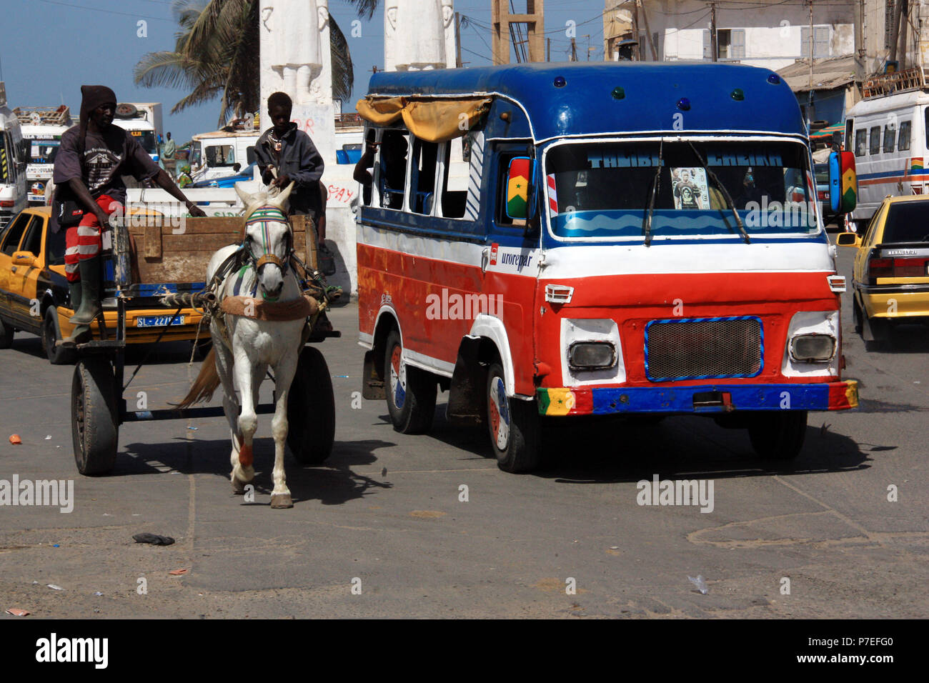 Bustling main street in Saint-Louis-du-Sénégal: Minibus overtaking two ...