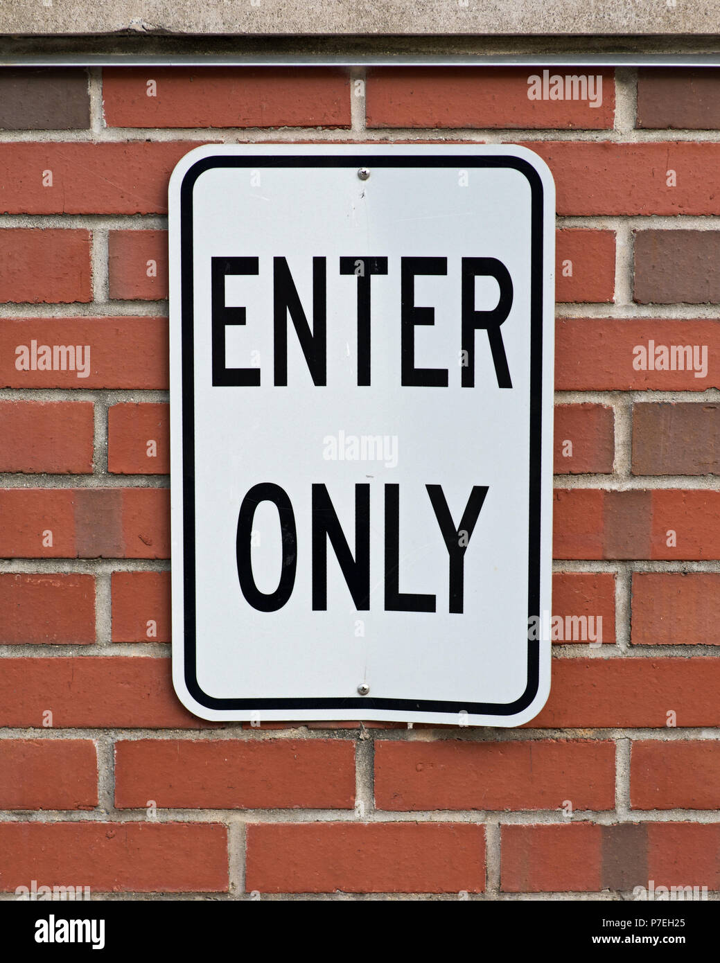 Parking lot sign ENTER ONLY on brick wall Stock Photo - Alamy