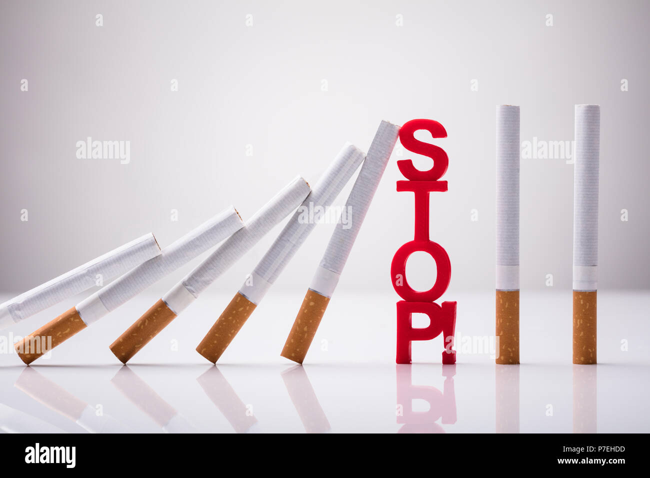 Falling Cigarettes Stopped By Stop Word Against White Background Stock ...