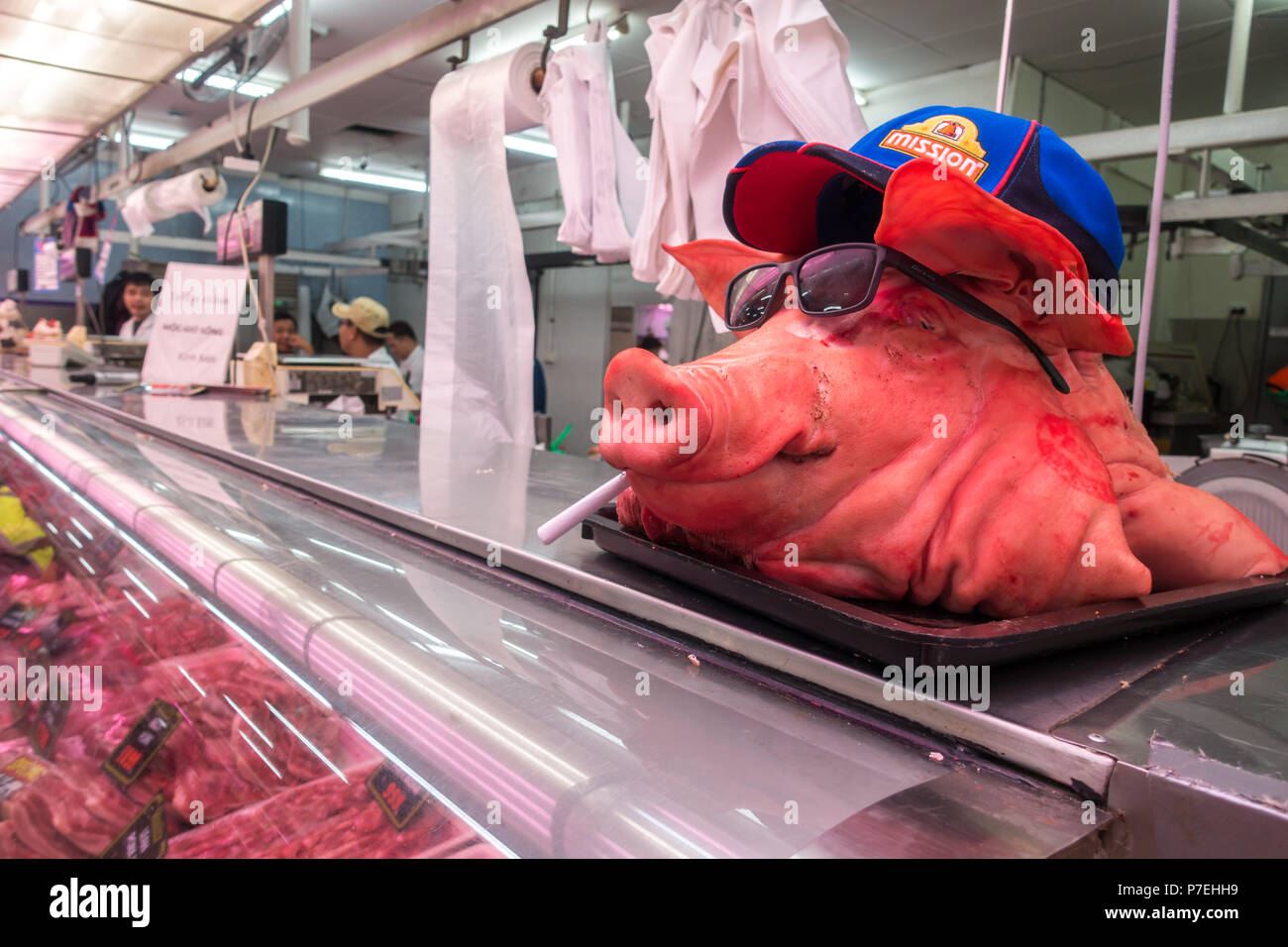 Pig's head placed on butcher shop counter and decorated with cigarette ...