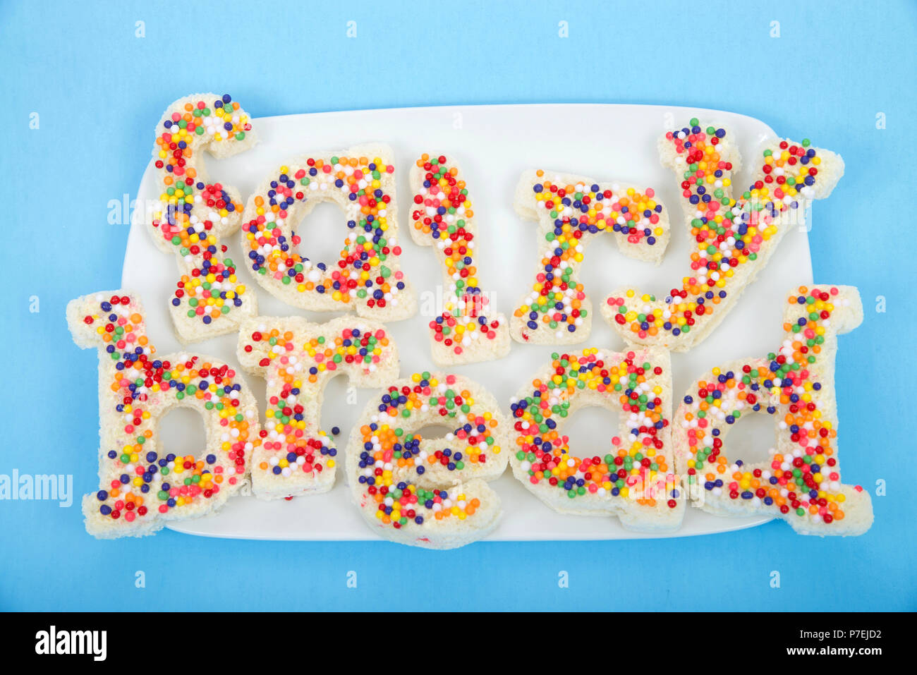 Fairy bread spelled with fairy bread on a white rectangular plate on ...