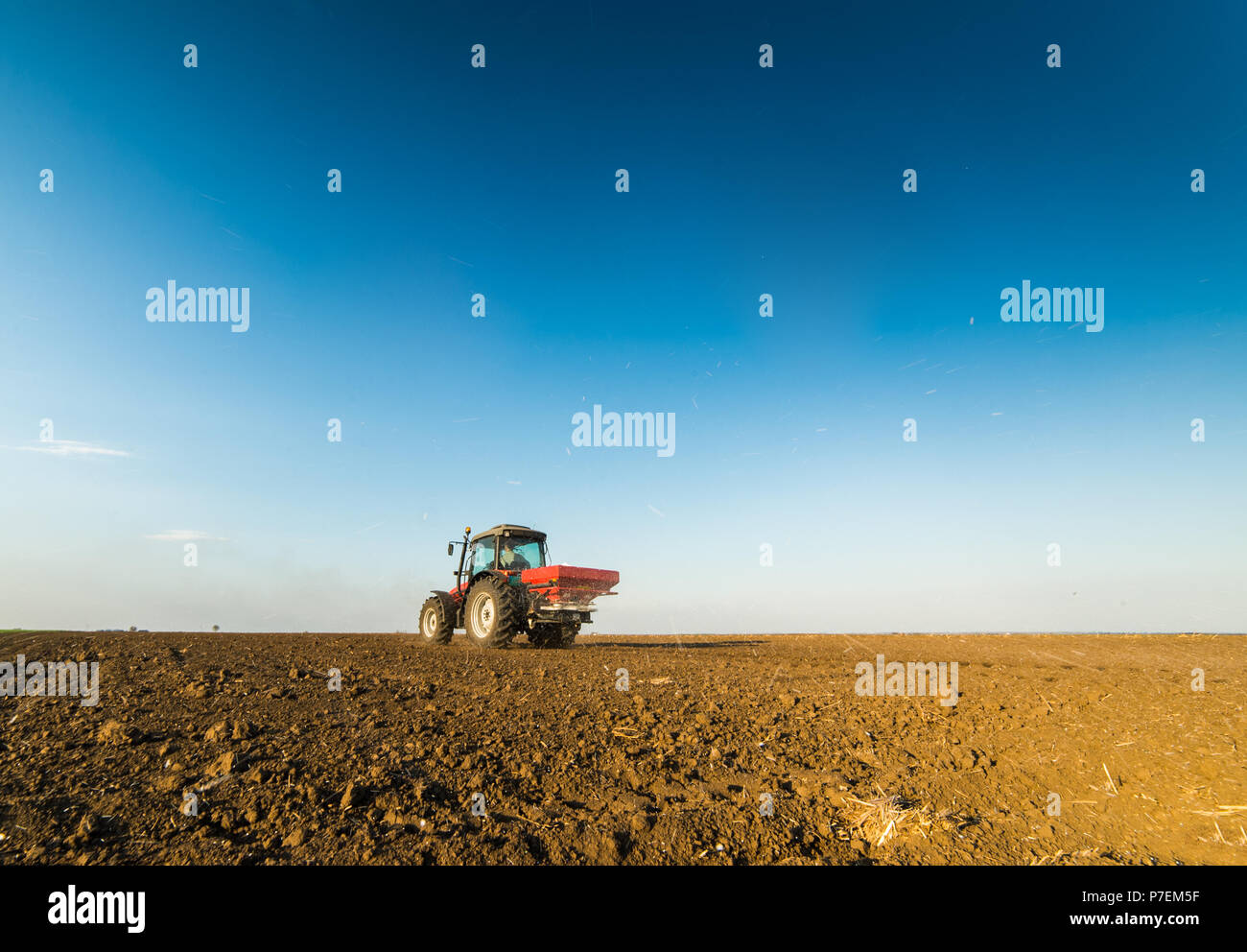 Tractor spreading artificial fertilizers in field Stock Photo - Alamy