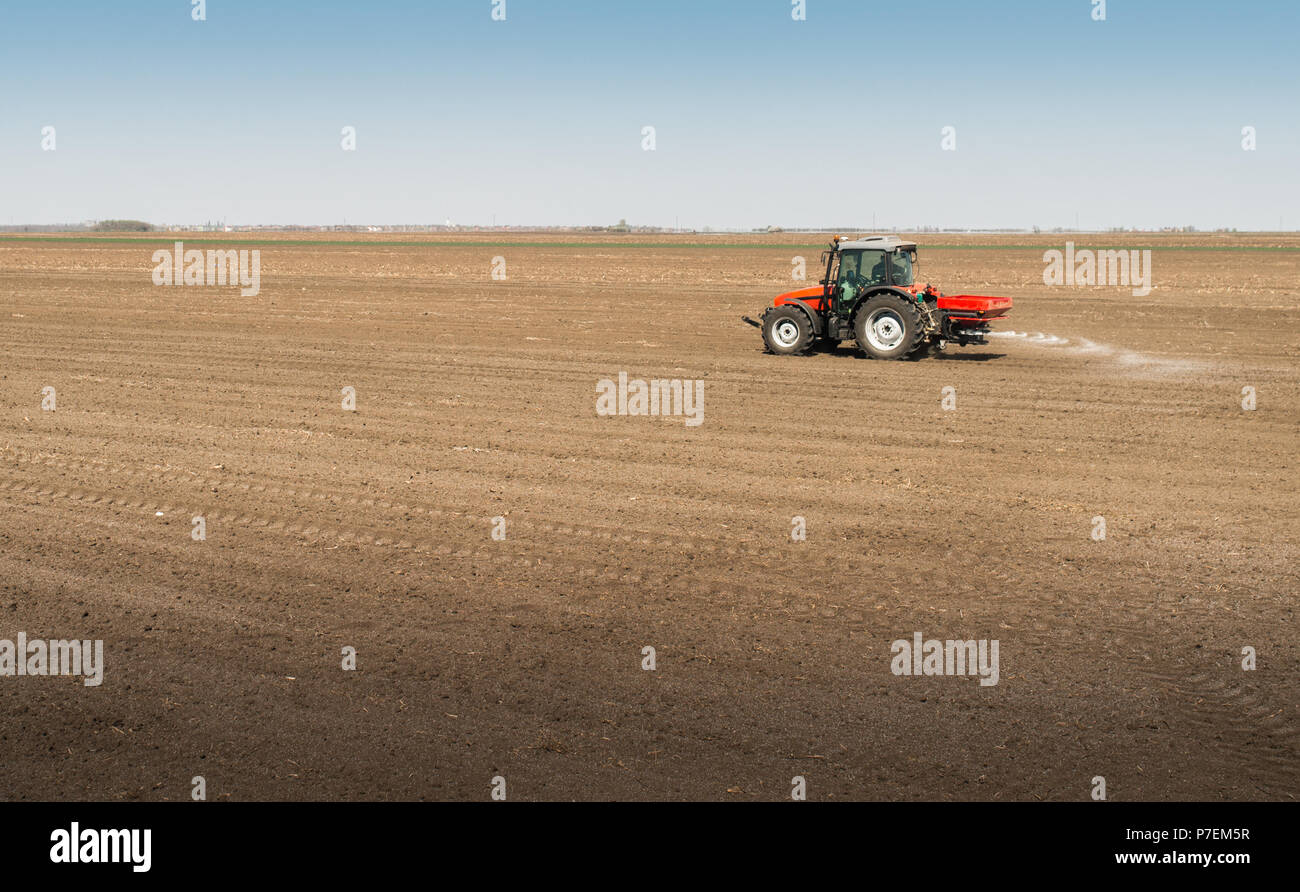 Tractor spreading artificial fertilizers in field Stock Photo - Alamy