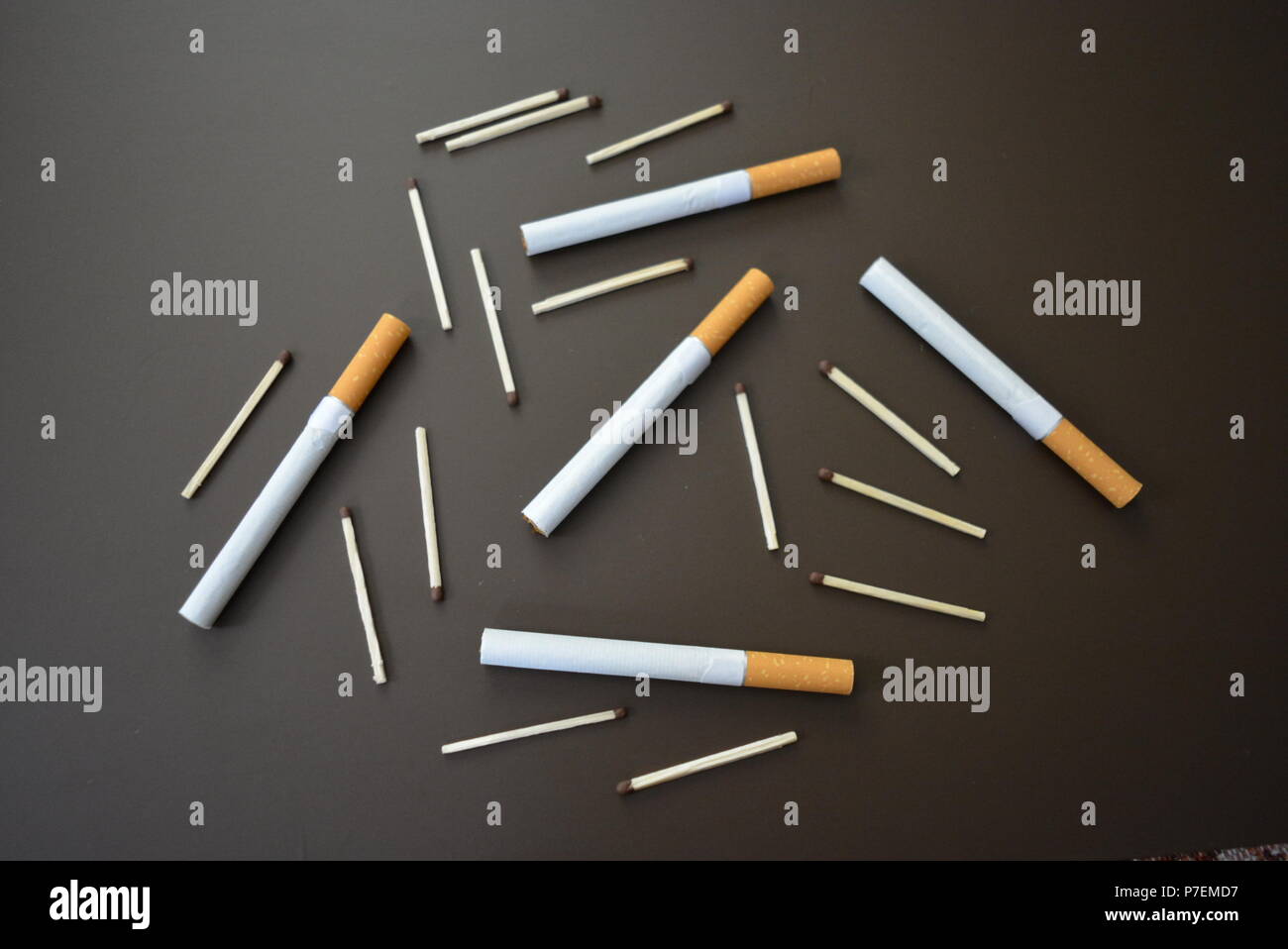 New cigarettes with matches on a brown matte background Stock Photo - Alamy