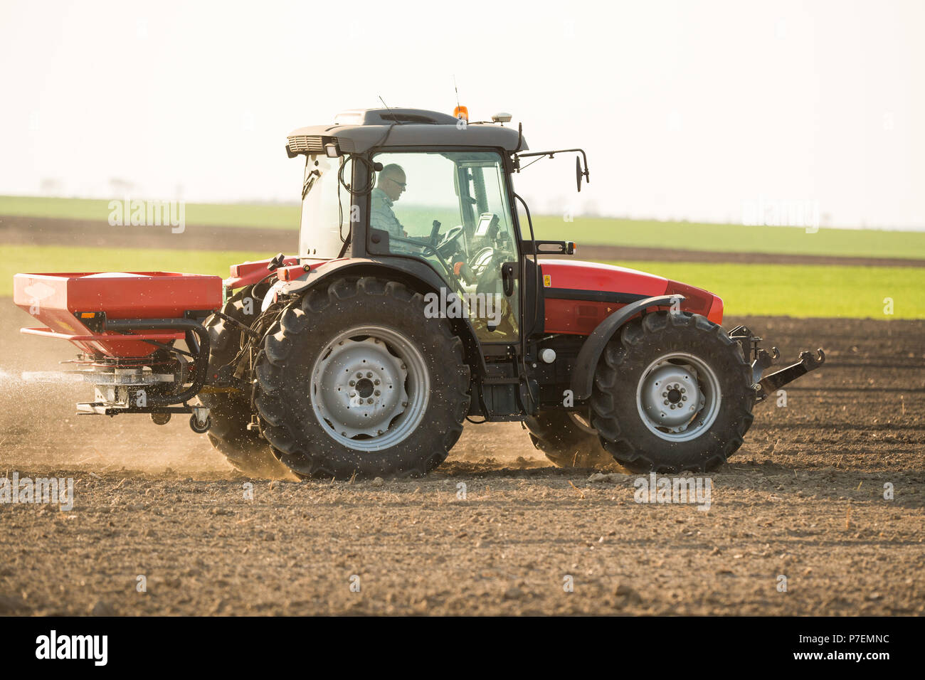 Tractor spreading artificial fertilizers in field Stock Photo - Alamy