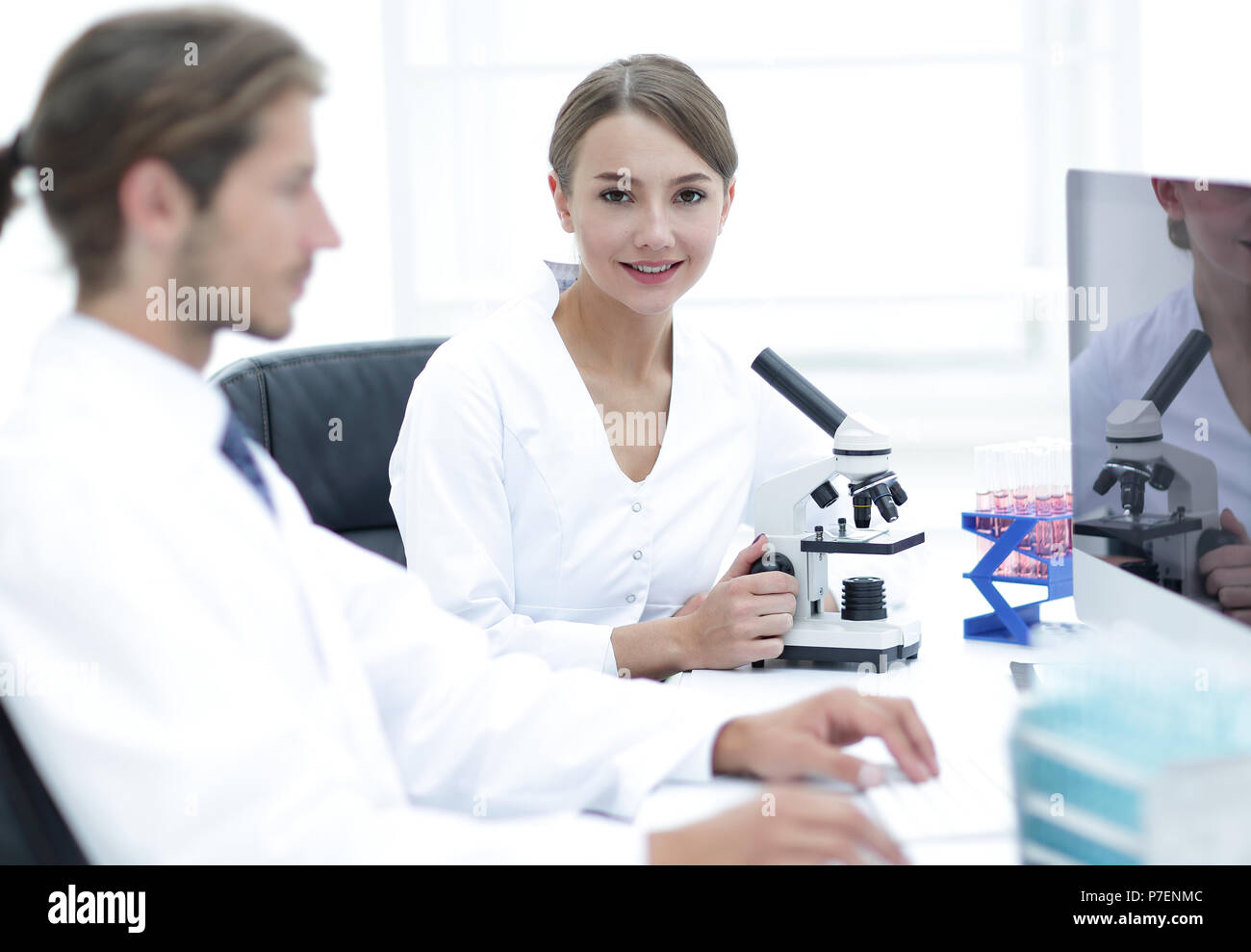 Lab expert working on a test using microscope Stock Photo - Alamy