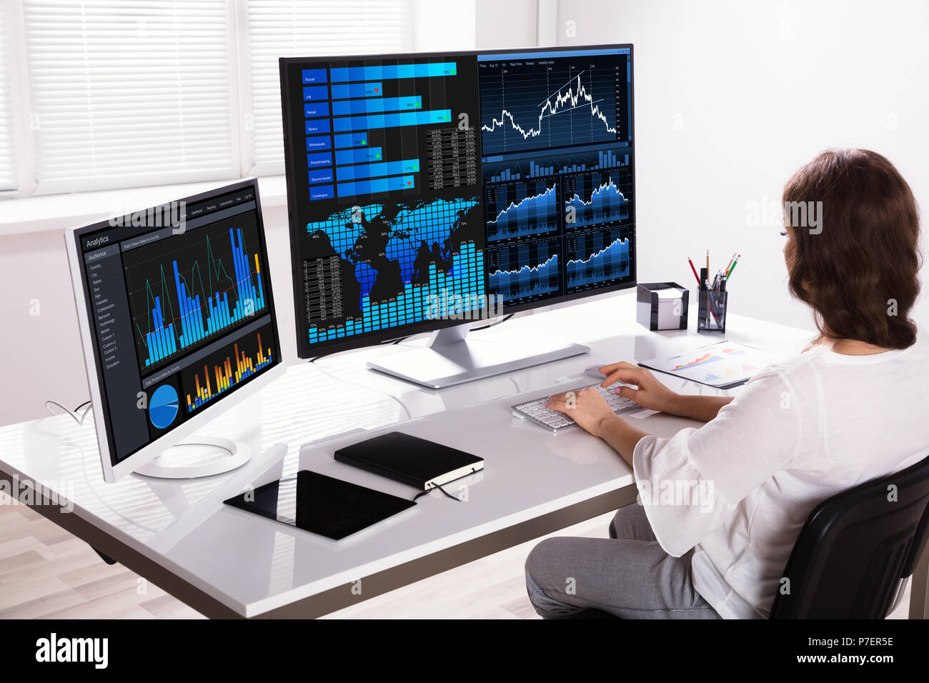 Female Stock Market Broker Analyzing Graphs On Computer At Workplace ...