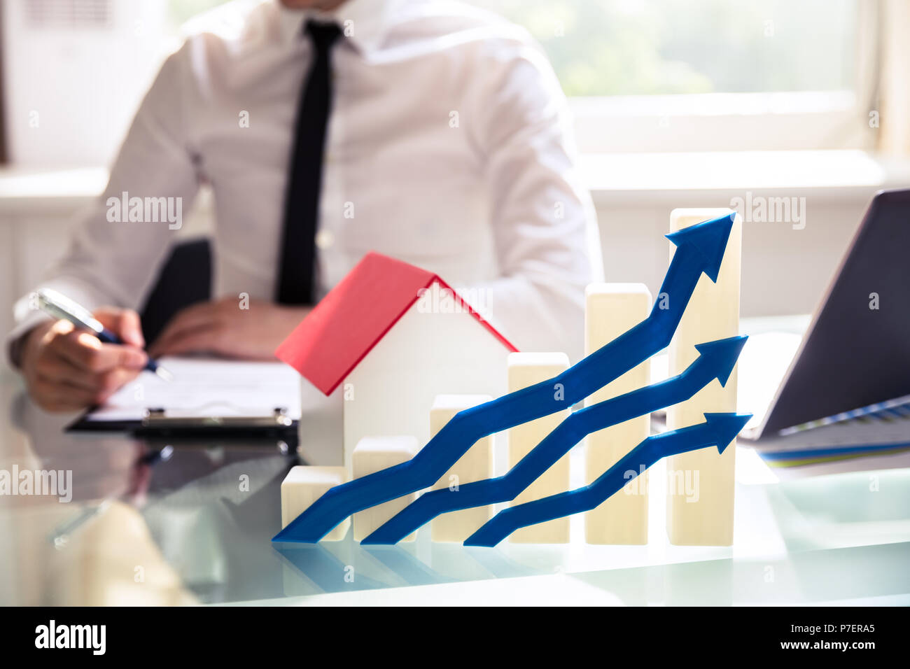 Close-up Of Increasing Blue Arrows And Graph In Front Of House Model ...