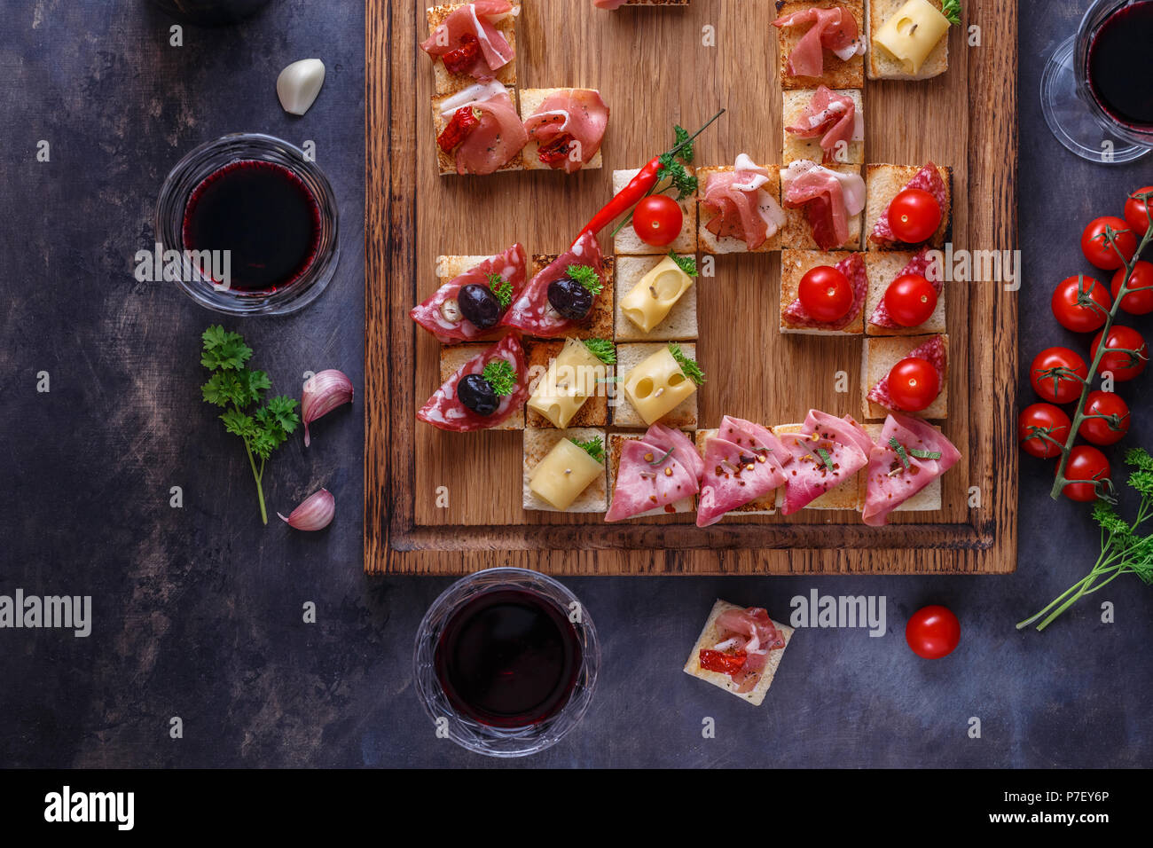 Appetizers table with italian antipasti snacks and wine in glasses ...