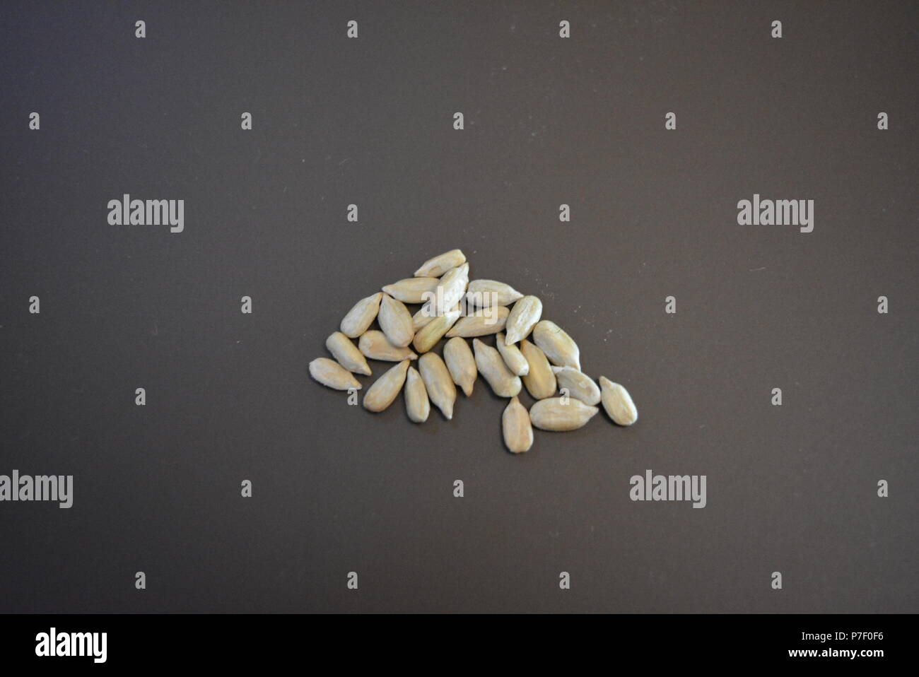 Fried sunflower seeds without black shell on matte brown background ...