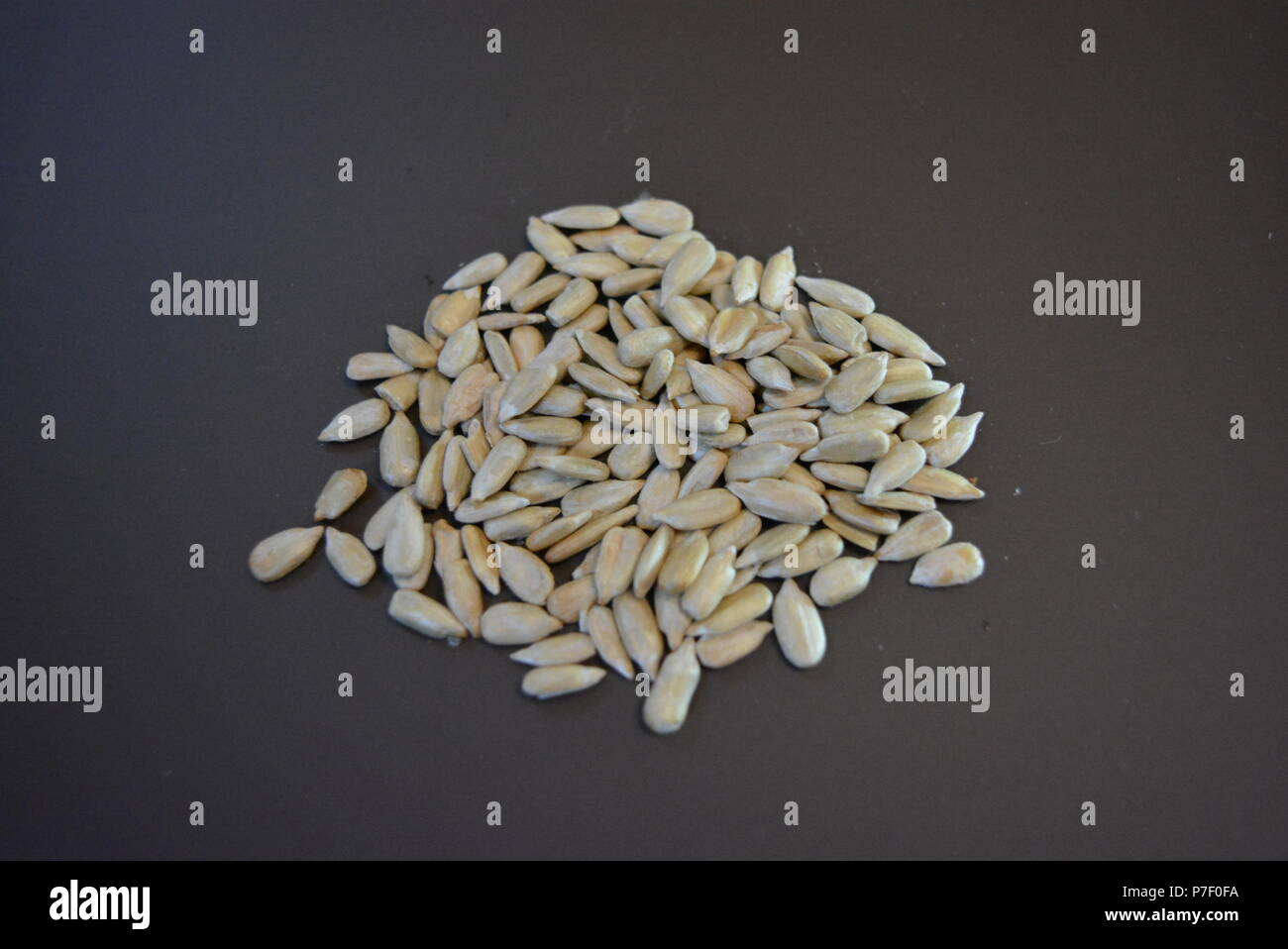 Fried sunflower seeds without black shell on matte brown background ...