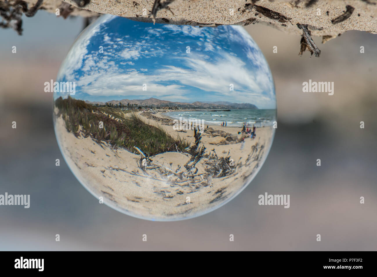 Hanging fish eye globe showing distorted view of beautiful beach day on ...