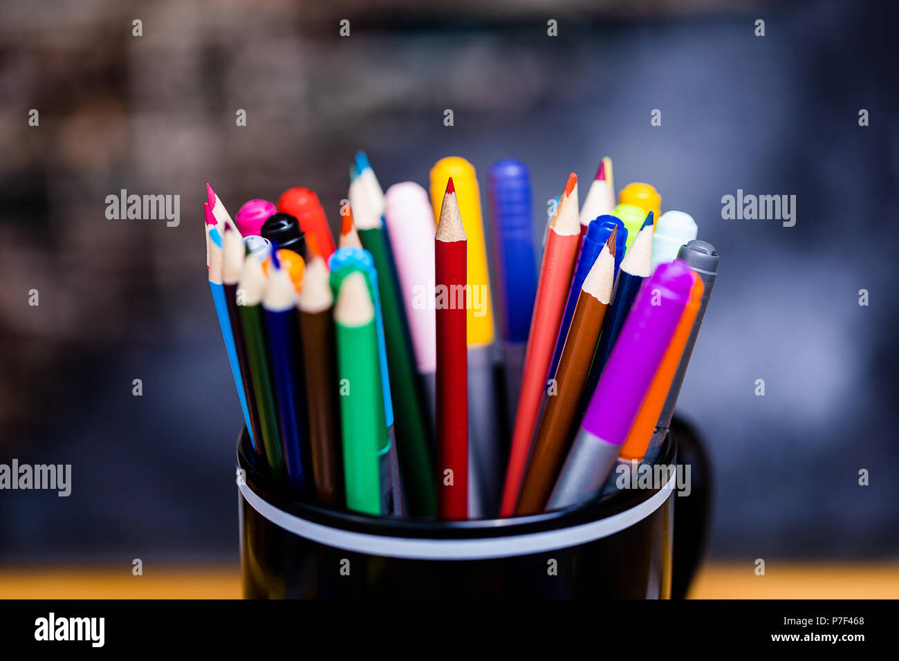 Mixed Colored Pencils and Markers in a cup with a very shallow depth of ...