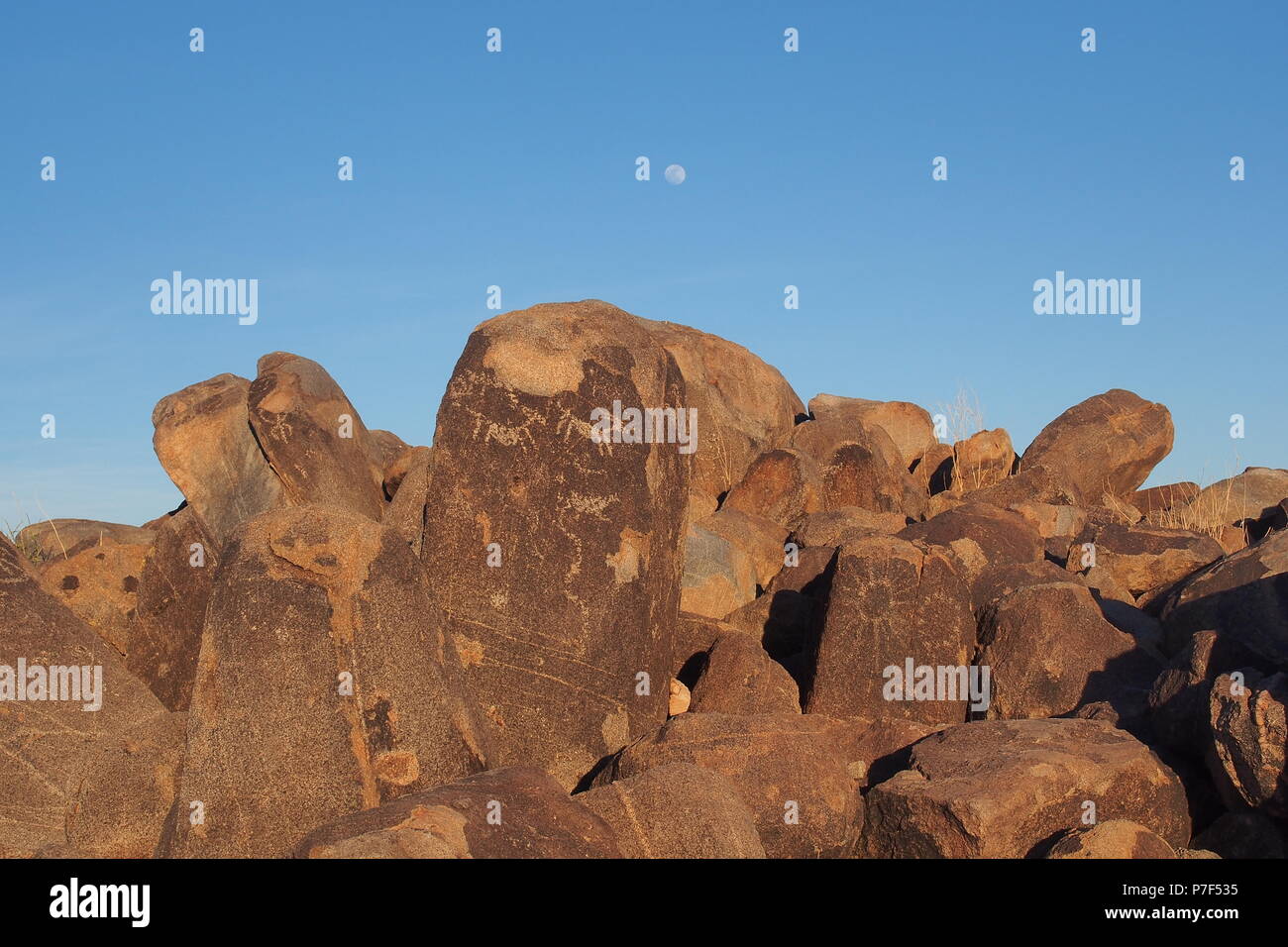 Rising moon behind rocks with Hohokam petroglyphs on Signal Hill in ...