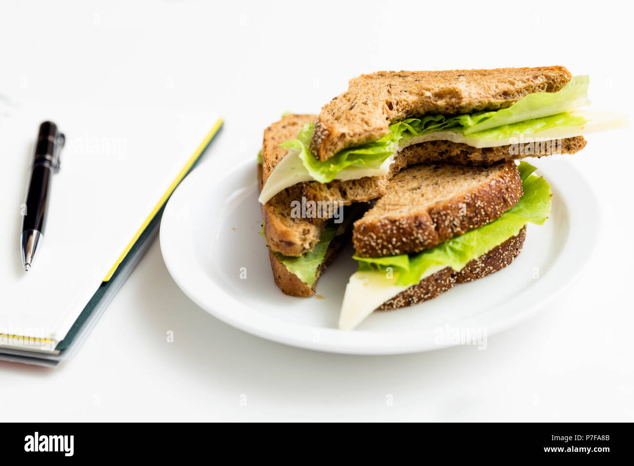 Sandwich from fresh toast with cheese and salad on work place. Work ...