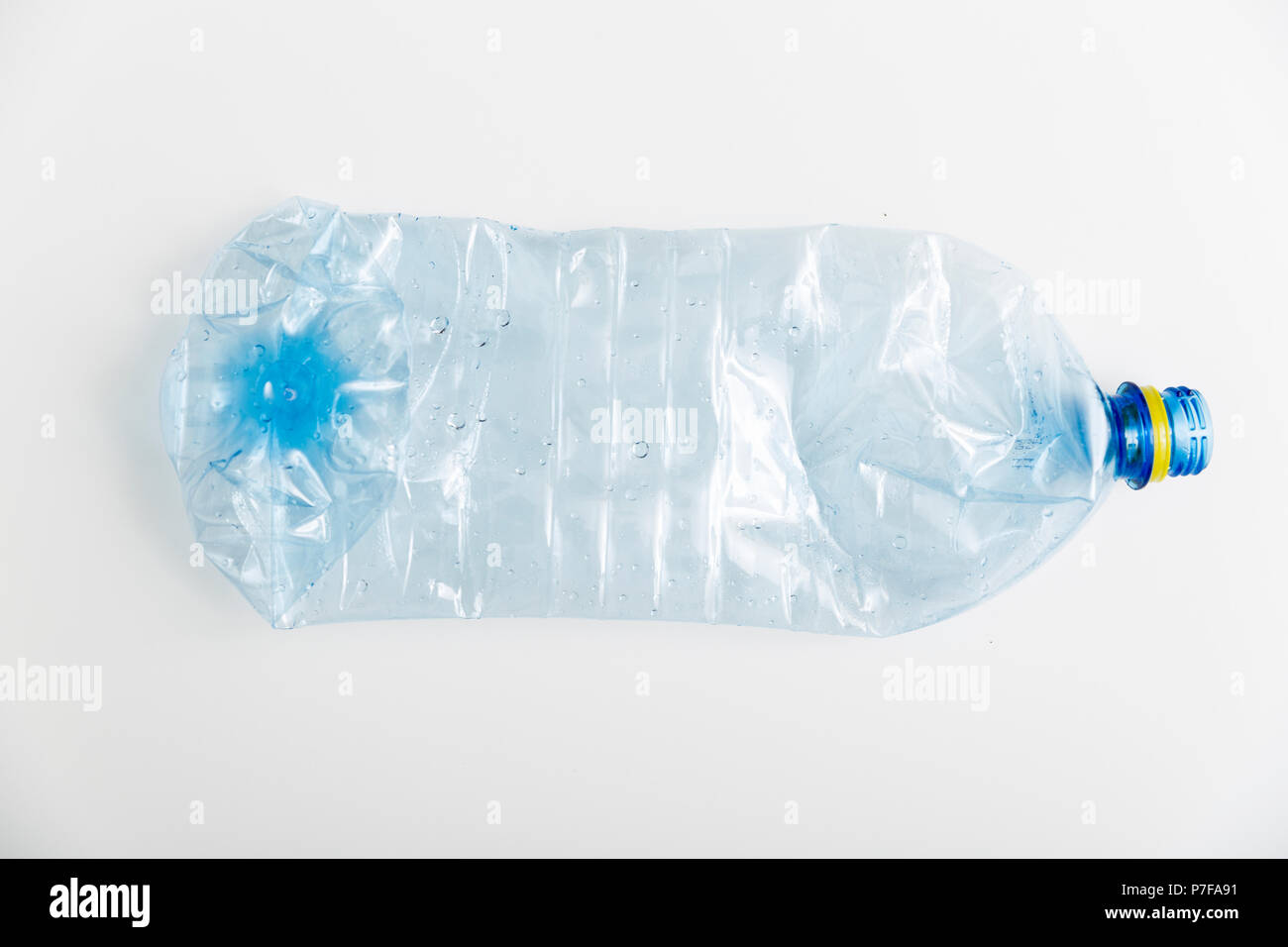 Crushed blue plastic bottle on white background. pollution concept ...