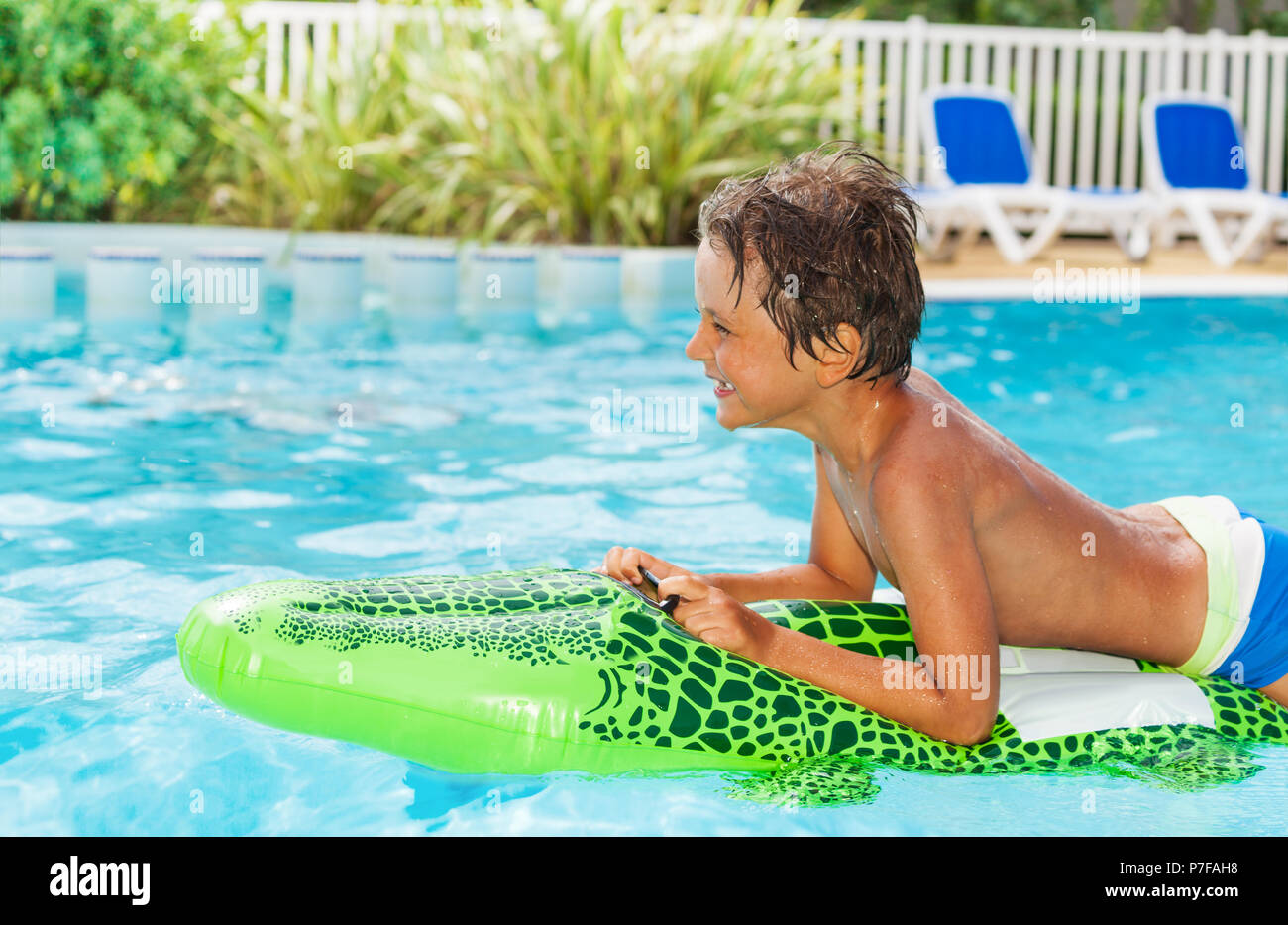 Boy floating on inflatable toy in swimming pool Stock Photo - Alamy