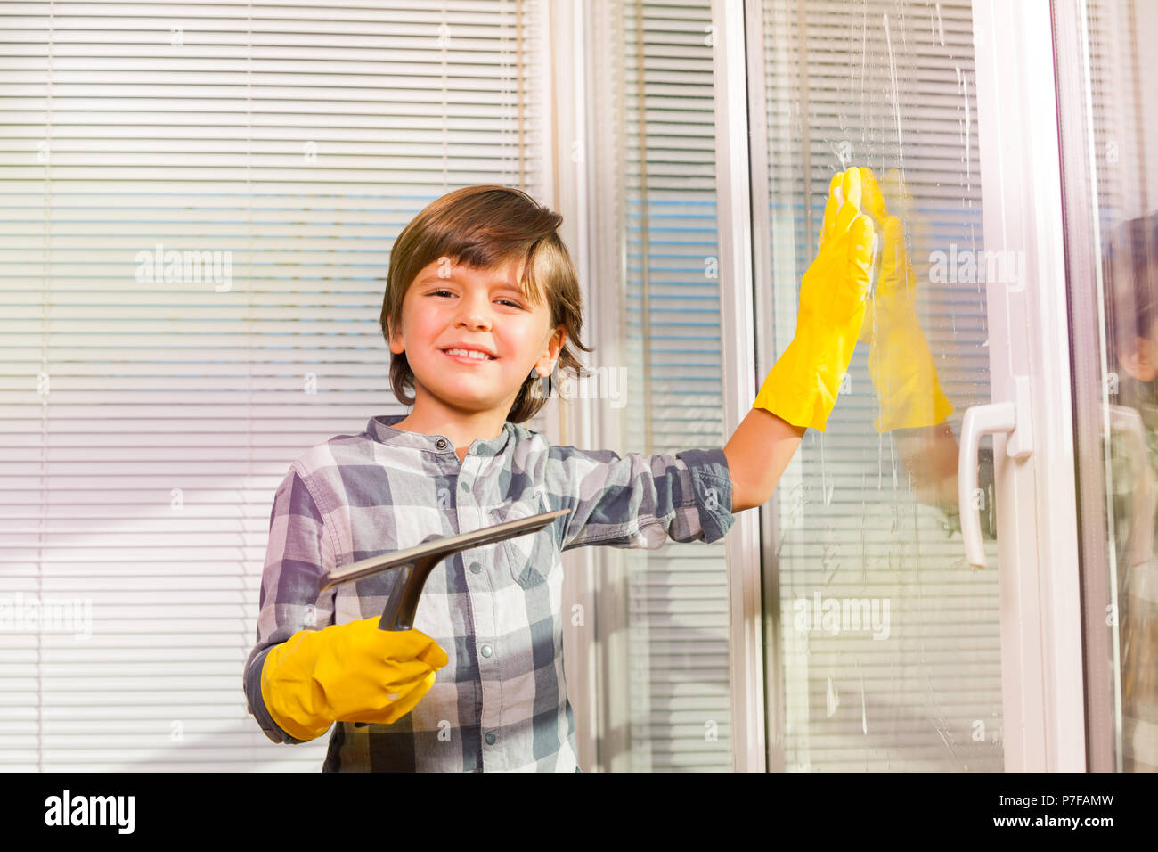Happy boy washing windows with sponge and brush Stock Photo - Alamy