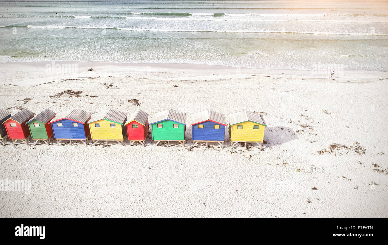 Multi colored wooden huts by mountain at beach Stock Photo - Alamy