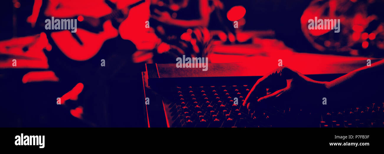 Hand operating sound mixer while musicians practicing in nightclub ...