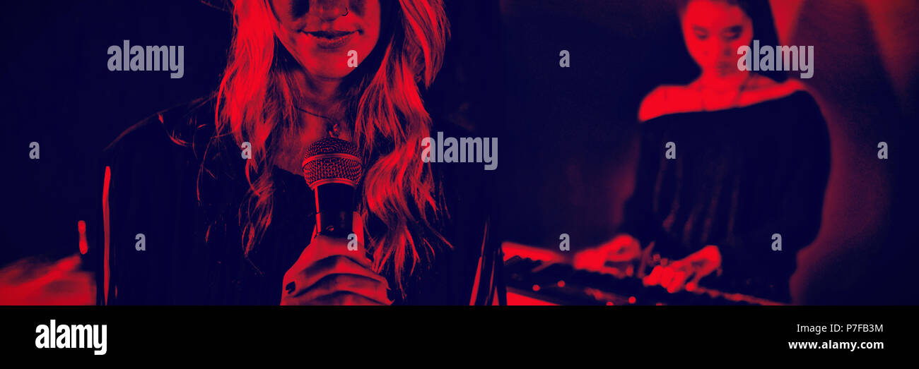 Confident singer performing with coworker in illuminated nightclub ...