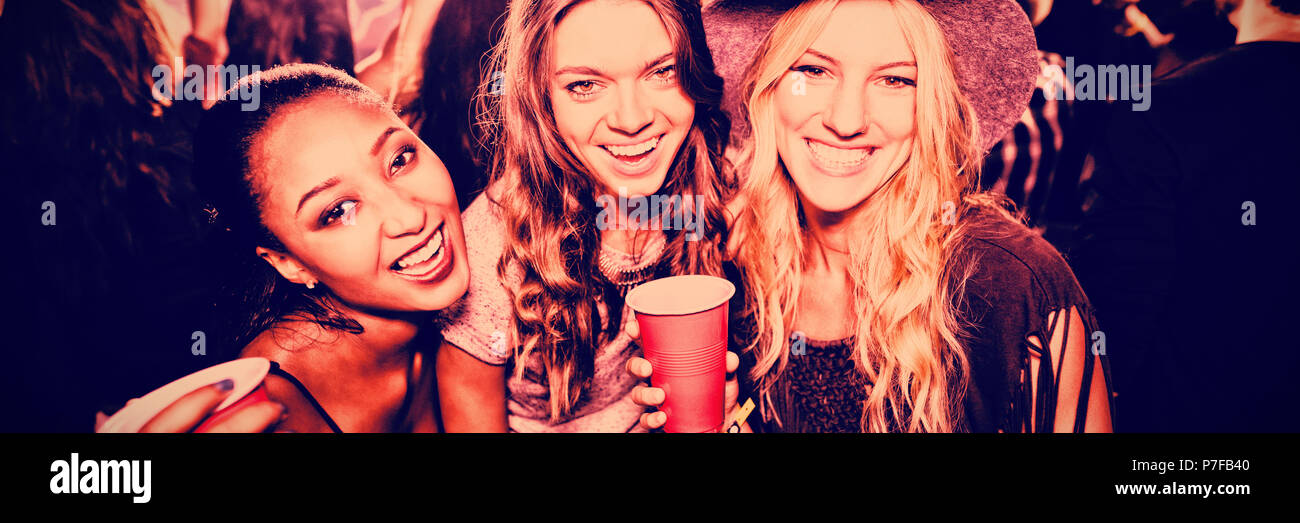 Female friends with disposable cups in club Stock Photo - Alamy