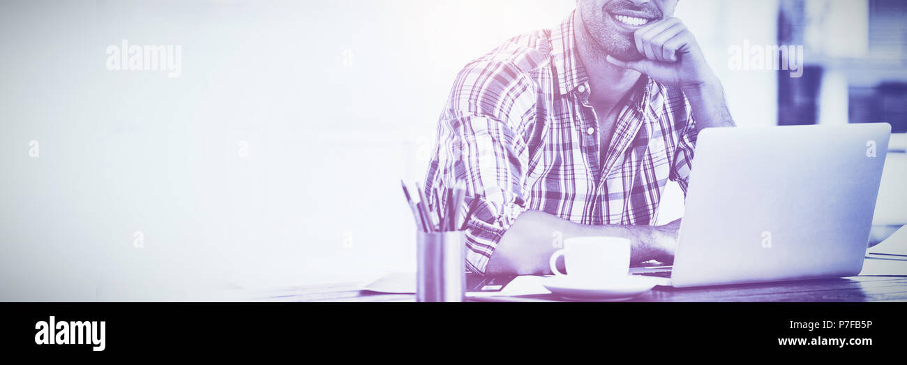 Young man sitting at his desk Stock Photo - Alamy
