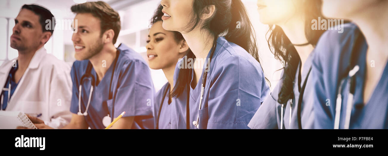 Medical students listening sitting at desk Stock Photo - Alamy