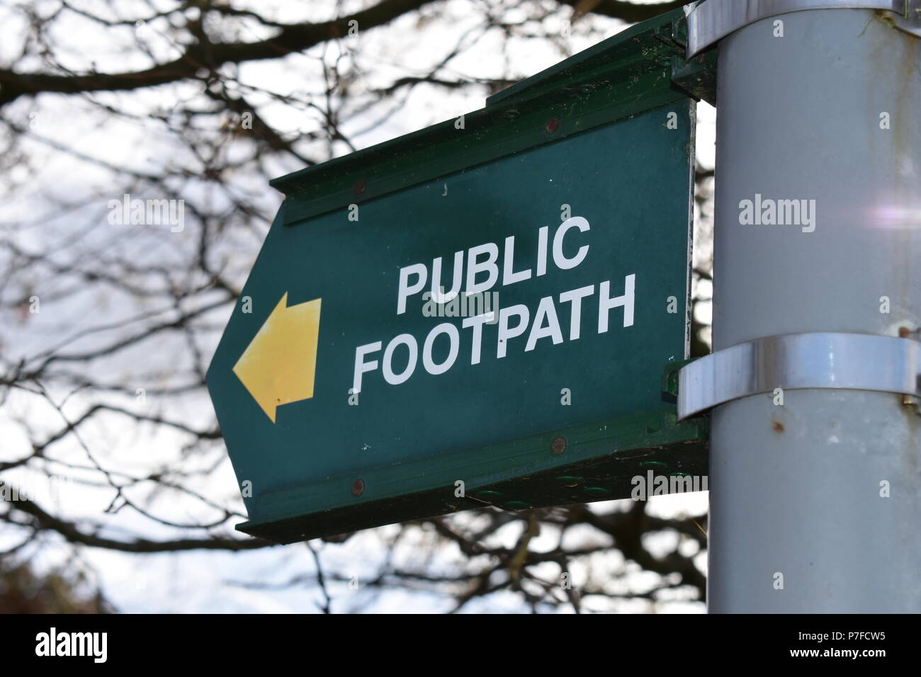 Metal green public footpath sign pointing left Stock Photo - Alamy