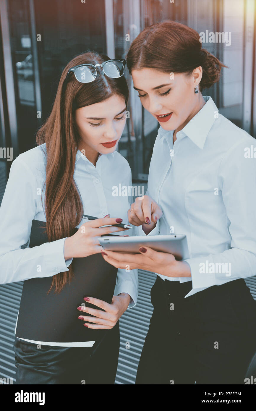 Business lady. Office staff. Two young girls with electronic tablets ...