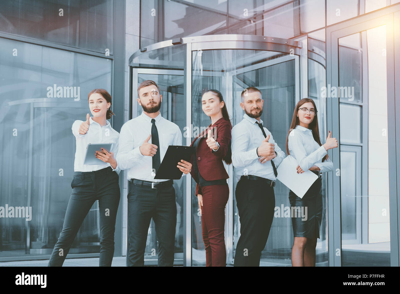 Command. Young office workers on the background of a multi-storey glass ...