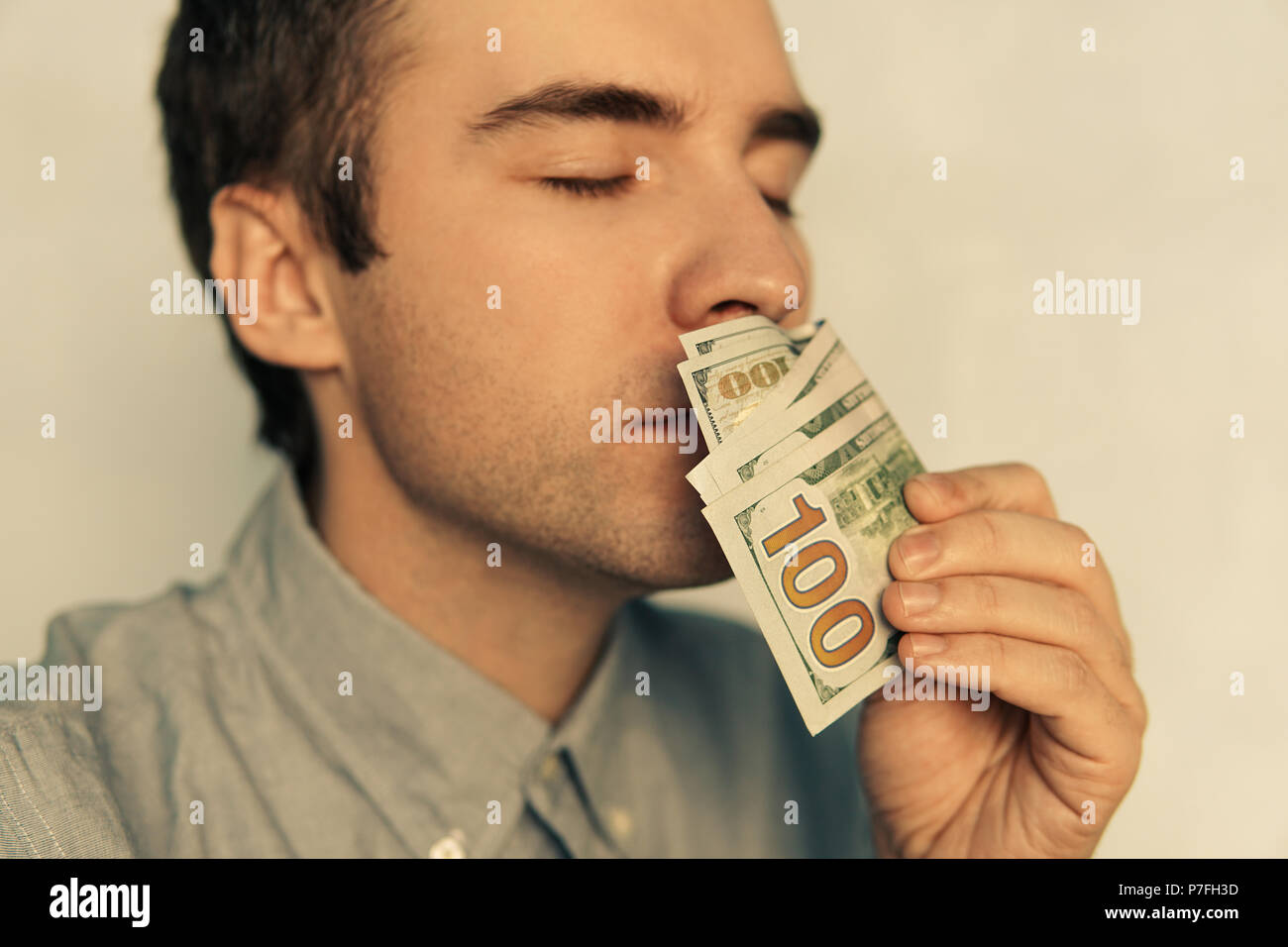 Man sniffing dollars. The sweet smell of money. Young guy sniffing 500 ...