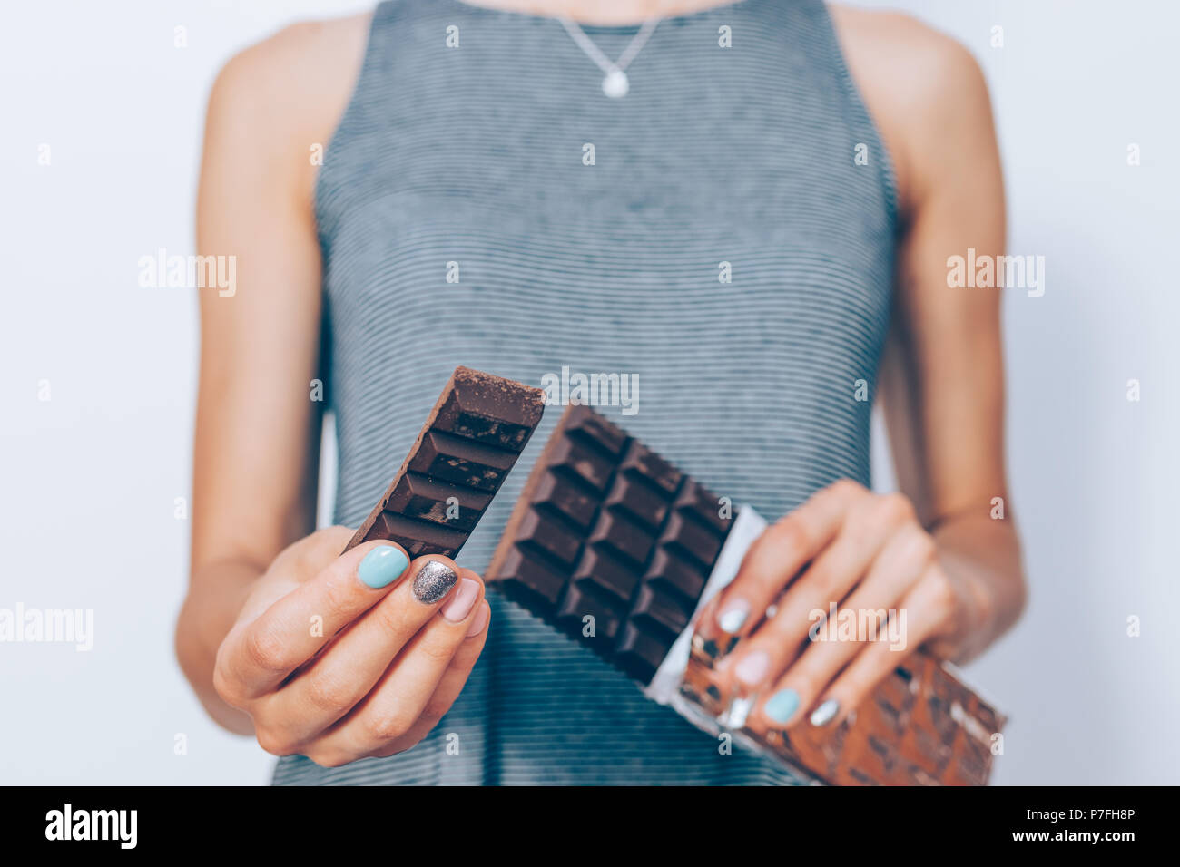 Woman's hands holding dark chocolate bar and slice of it, close-up ...