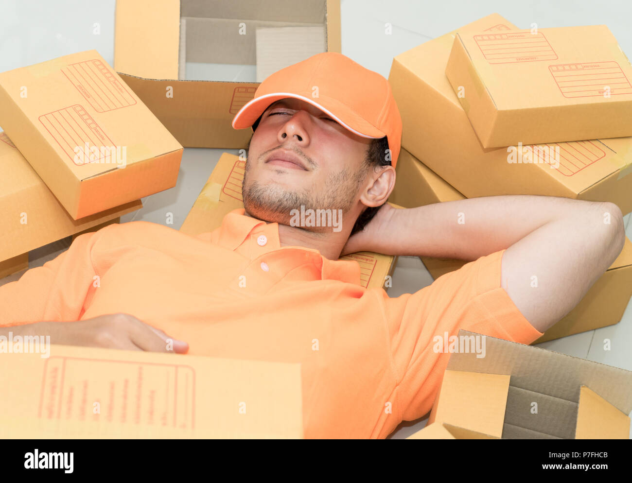 Delivery man is relaxing taking a nap on boxes Stock Photo - Alamy
