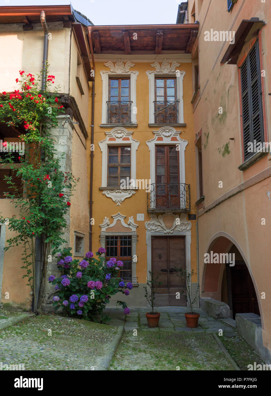 summer image of an ancient village with flowers on the facades of ...