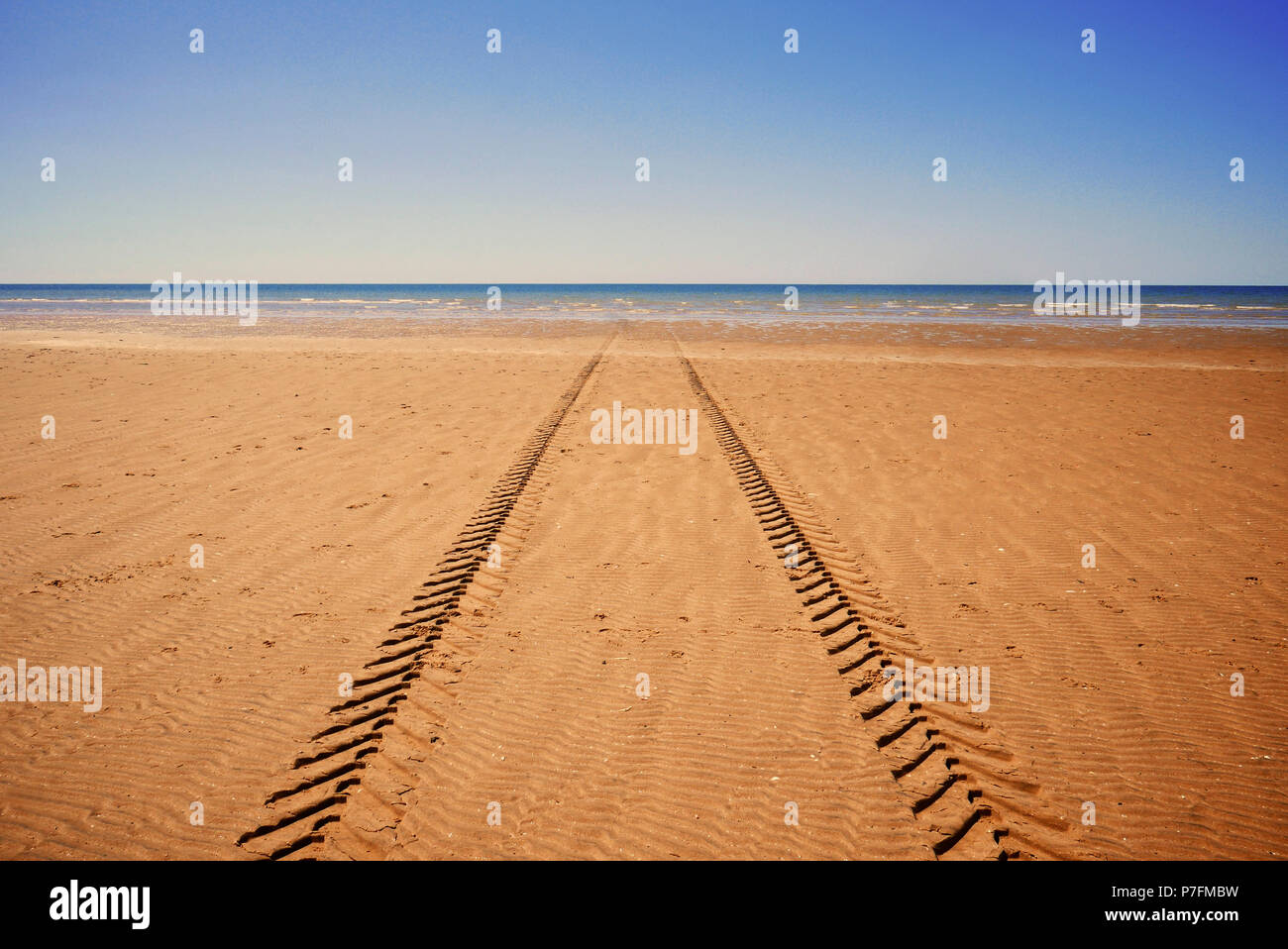 Vehicle tracks in sand leading into the sea Stock Photo - Alamy