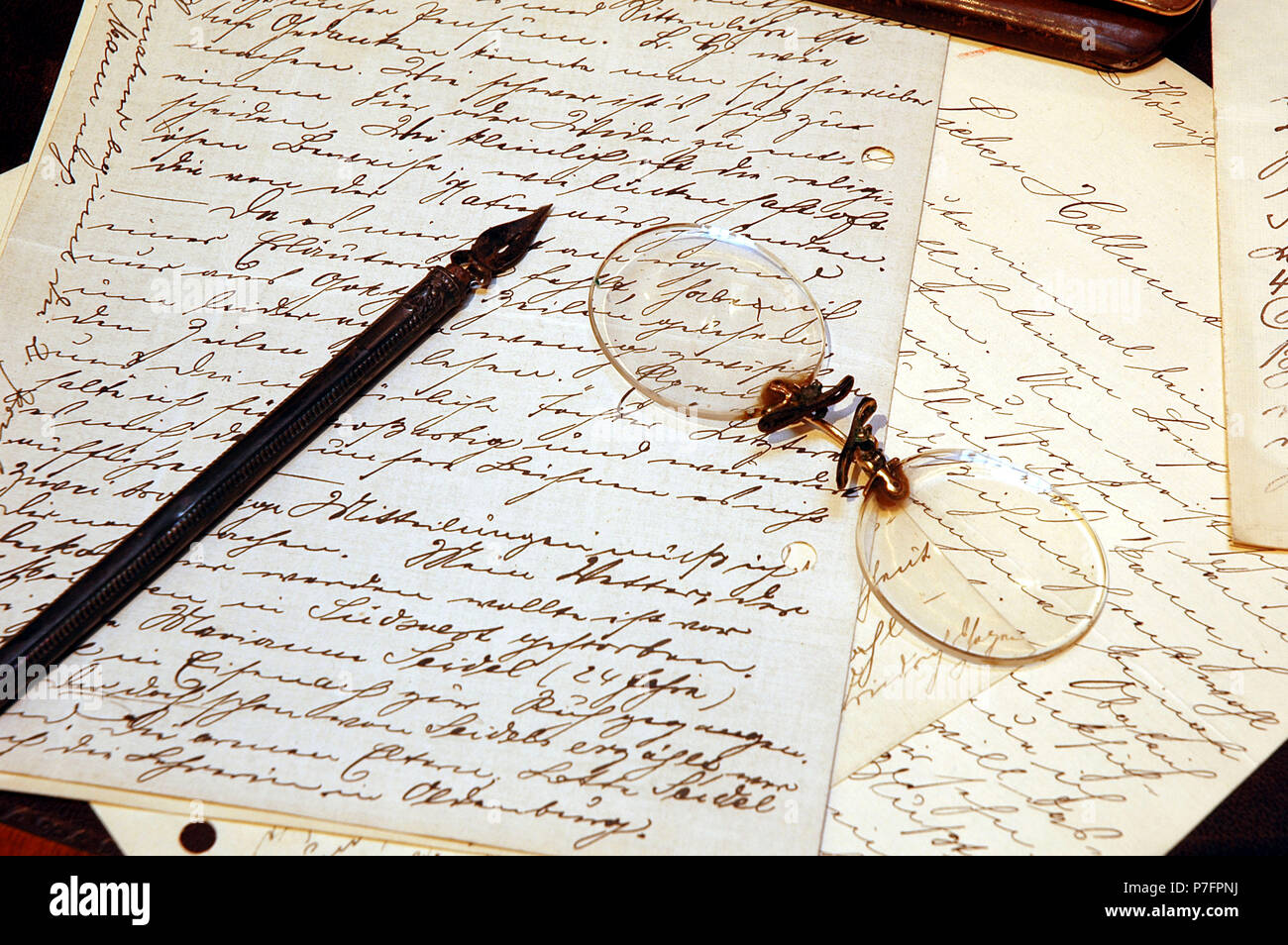 Old fountain pen and glasses on written paper, symbol picture for ...
