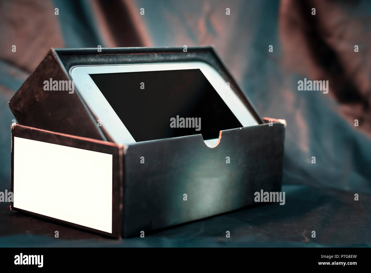 Close up of an Un -boxed digital smart phone in its box on a dark shiny ...